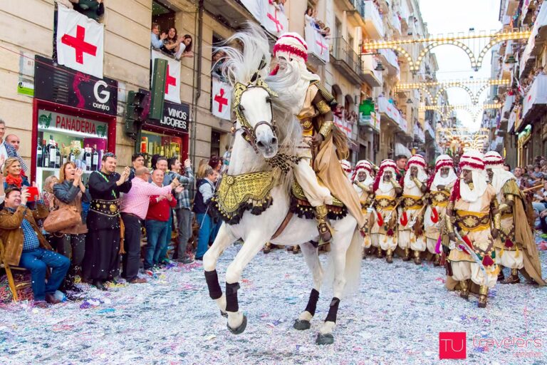 A man dressed as a Moor rides a white horse through the crowd at the Moors and Christian parade in Alcoy