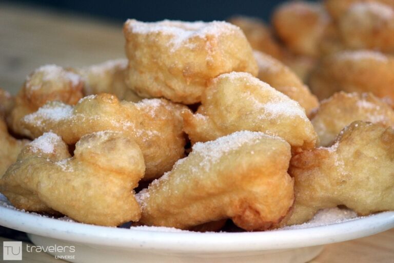 A plate of buñuelos sprinkled with sugar