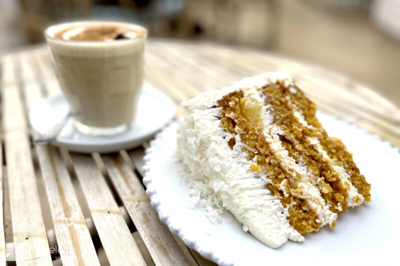 Cake and chai latte on a wooden table at La Mas Bonita, Valencia