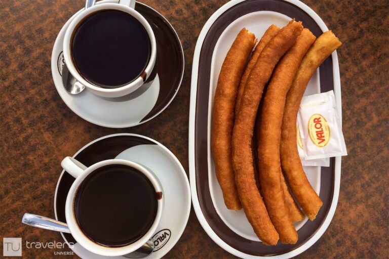 A plate of churros and a cup of hot chocolate on a table at Chocolates Valor