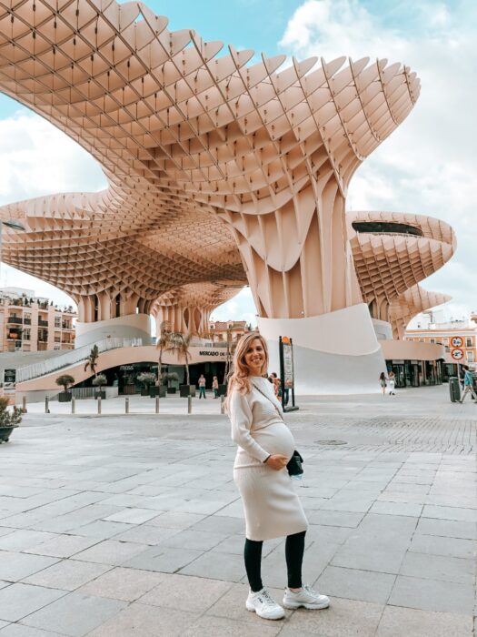 Pregnant Emily posing in front of Metropoli Parasol wooden structure in Seville 