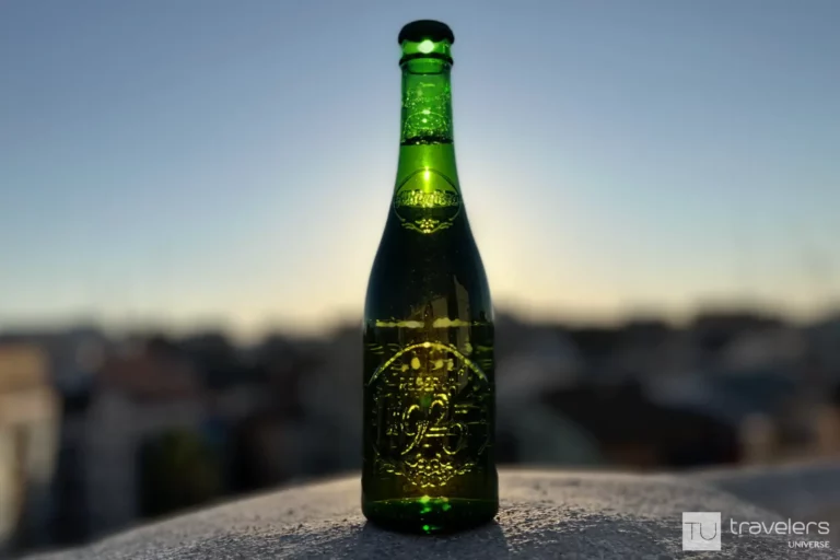 A bottle of Alhambra Reserva 1925, one of the best Spanish beers with the sun setting in the background