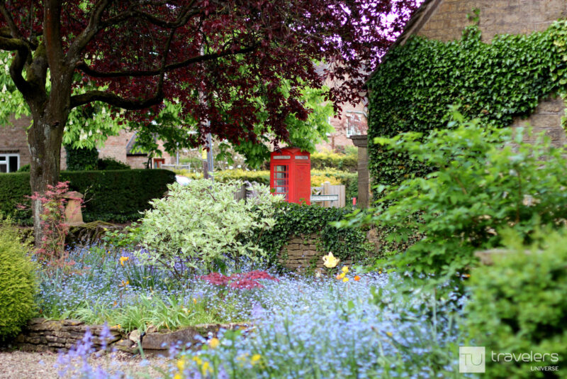 Flower garden with a red phone booth in Bourton-on-the-Water