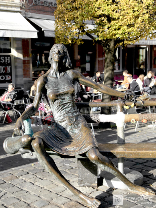 Statue of a young beautiful woman relaxing on a bench