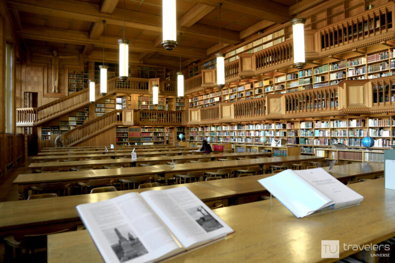 Tables, books and beautiful wood shelves inside the KU Leuven library
