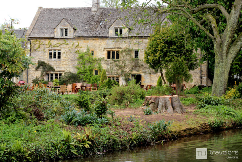 An old building with a coffee shop and terrace among greenery in Lower Slaughter