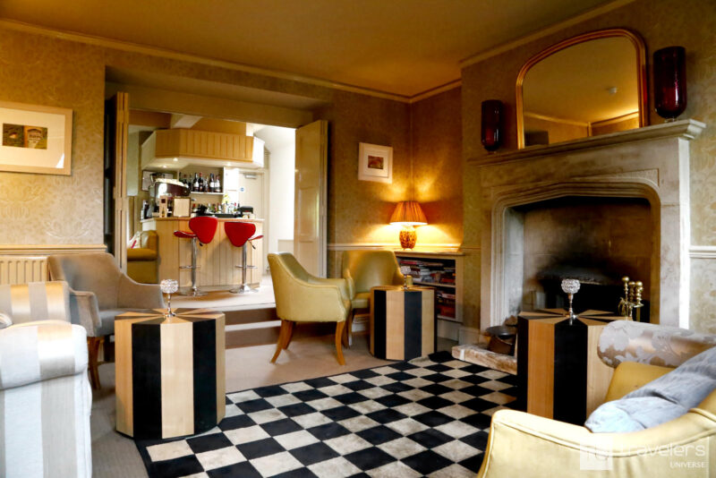 Warm toned lobby with old chimney, sofas and chairs at The Dial House Hotel in Bourton on the Water