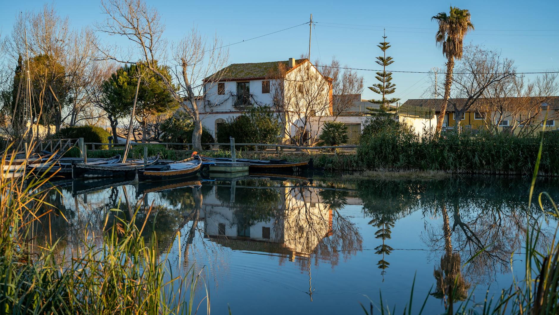 Traditional barraca house reflected in the calm waters of Albufera lagoon near Valencia