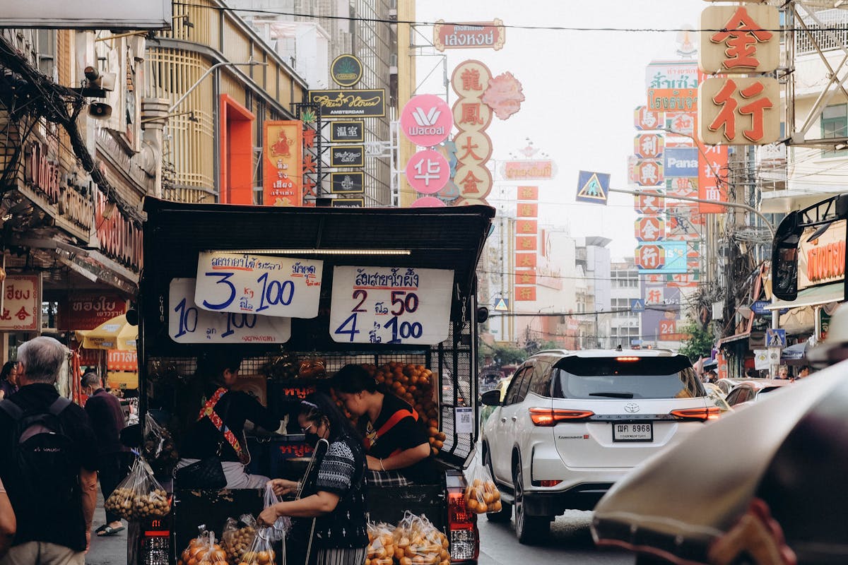 Street food stalls and neon signs along Yaowarat Road in Bangkok Chinatown at night