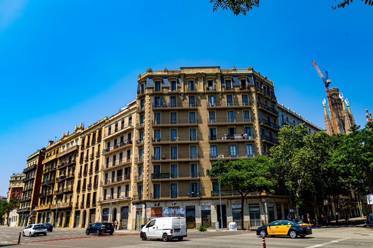 Street view of Barcelona Eixample neighborhood with the Sagrada Familia visible in the distance