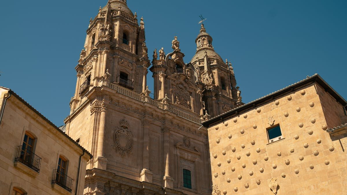 Salamanca Cathedral with its golden sandstone facade against a clear blue sky
