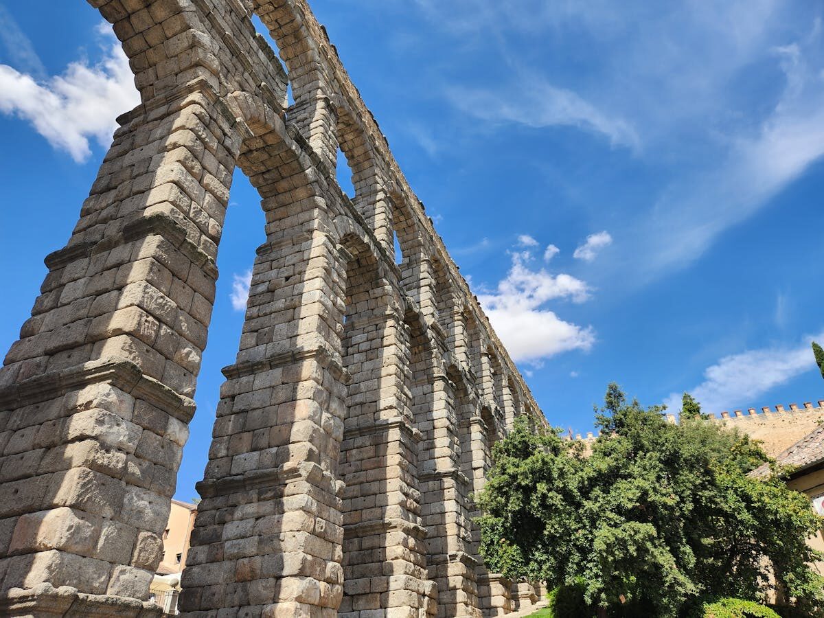 The Roman aqueduct of Segovia with its massive stone arches rising above the street