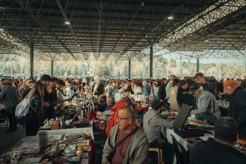 Crowded outdoor flea market with shoppers browsing stalls