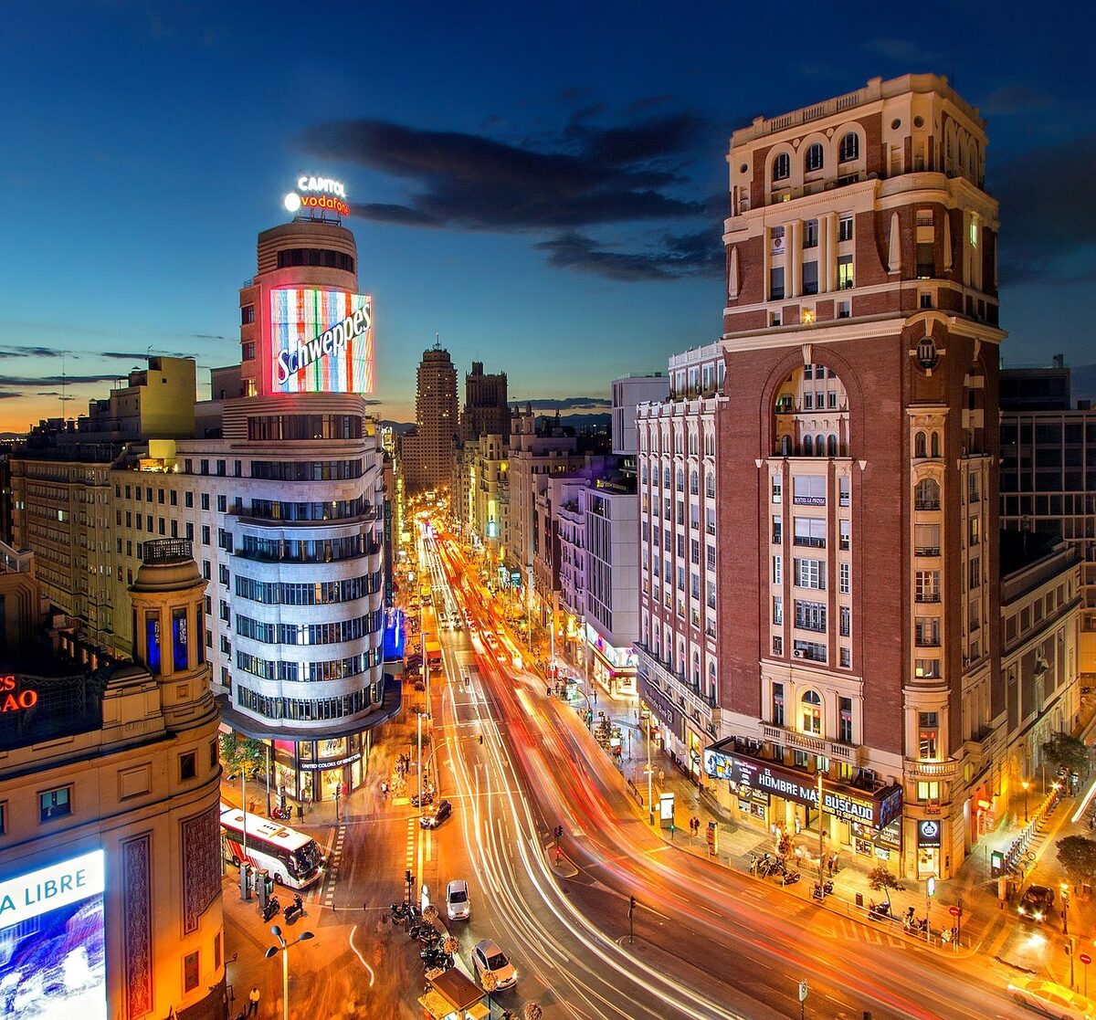 Gran Via boulevard in Madrid at dusk with traffic and illuminated buildings