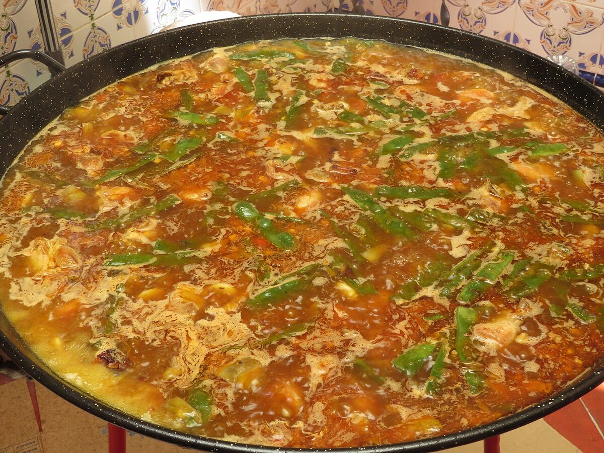 Broth beginning to simmer during the preparation of authentic paella Valenciana
