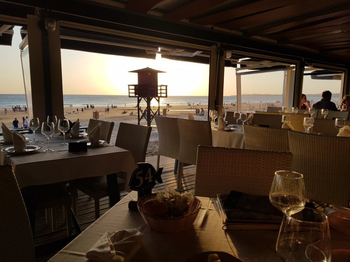 Beachfront restaurant dining at sunset along the Mediterranean coast