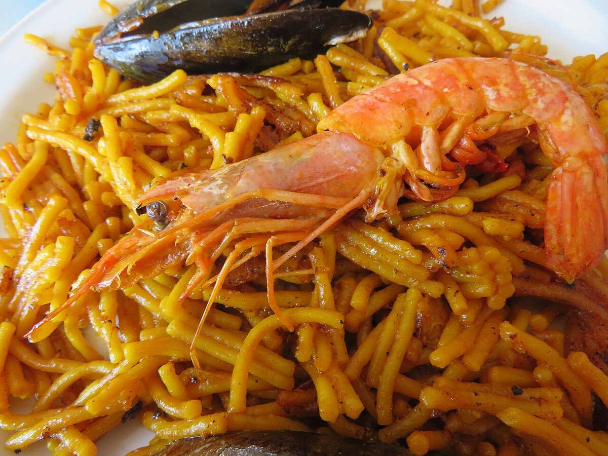 Fideua, a traditional Valencian noodle dish cooked in a paella pan