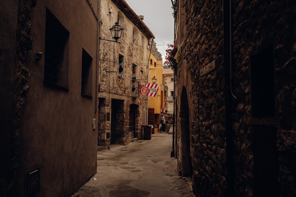 Narrow stone street between old buildings in a Spanish town