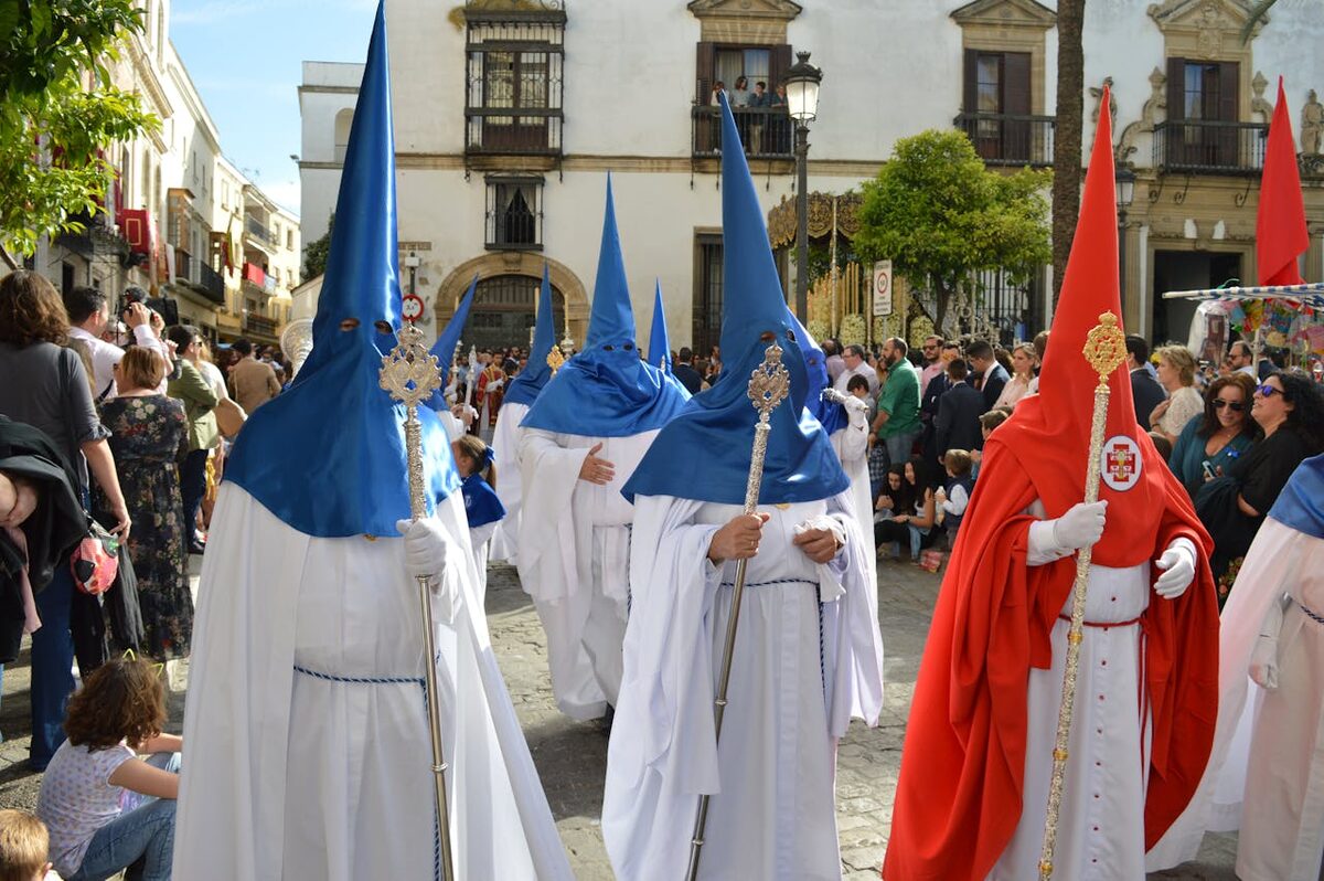 Hooded participants in traditional robes during Semana Santa procession in Seville