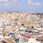 Aerial view of Seville historic architecture and rooftops under blue sky