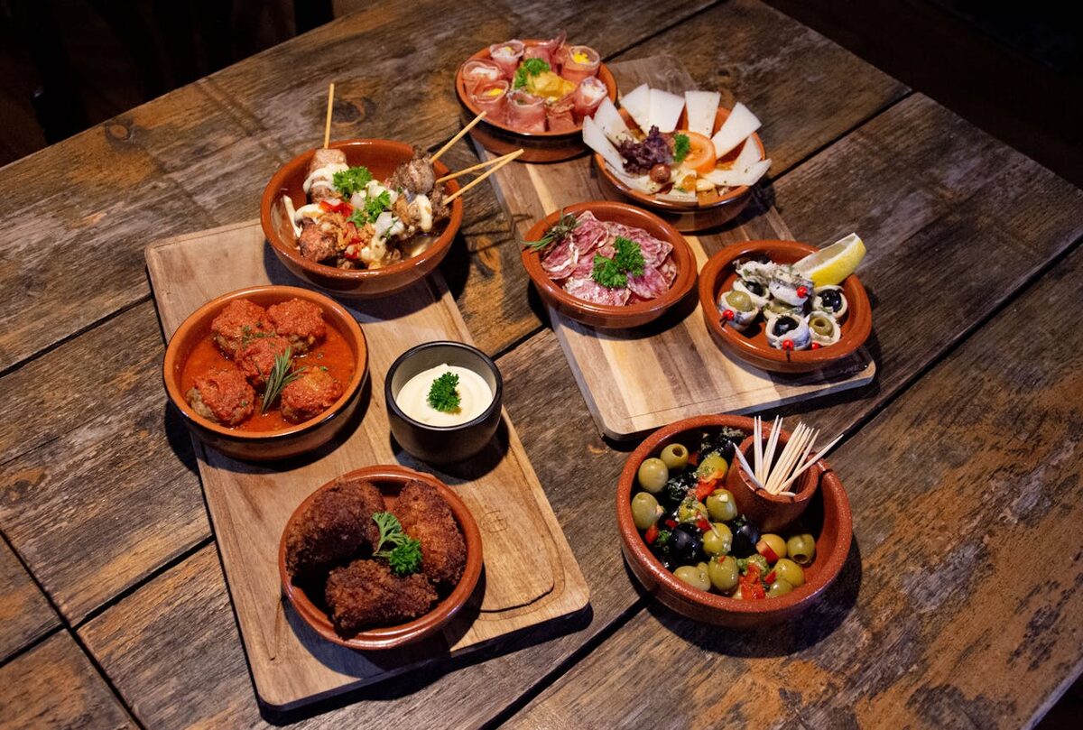 Assortment of traditional Spanish tapas dishes served on rustic wooden boards