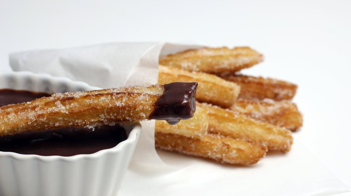 Sugar-coated churros served with rich chocolate sauce for dipping