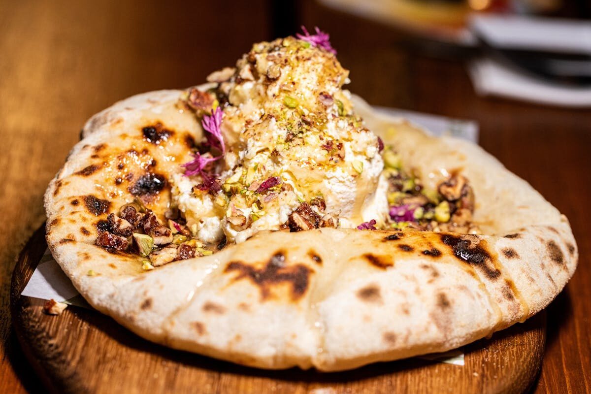 Sweet flatbread topped with honey nuts and edible flowers