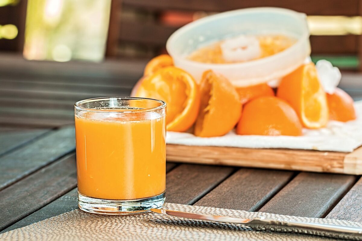 Glass of freshly squeezed orange juice with citrus fruit