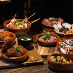 Assorted Spanish tapas dishes arranged on a wooden table