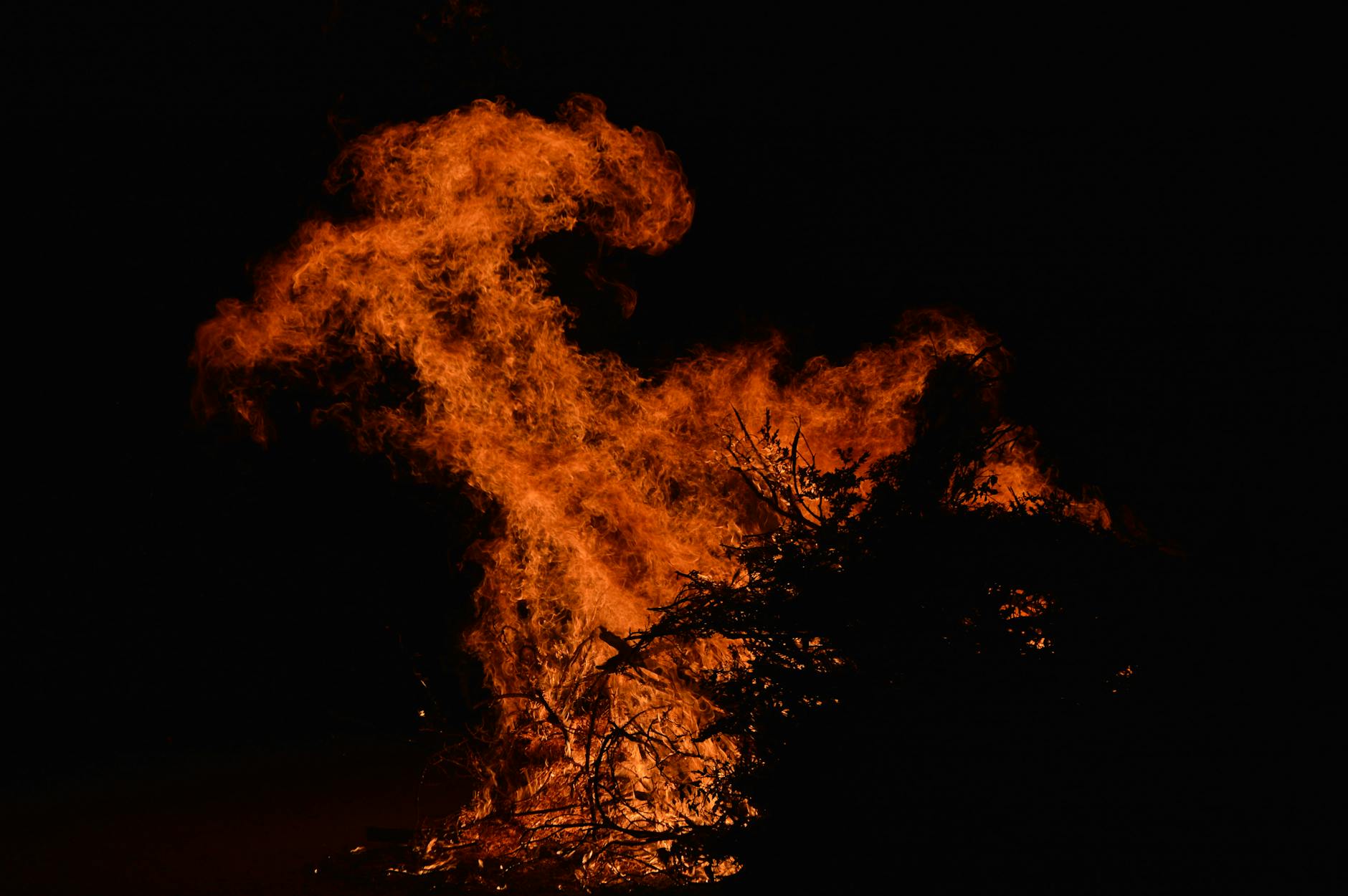 Massive bonfire blazing against the night sky during a festival