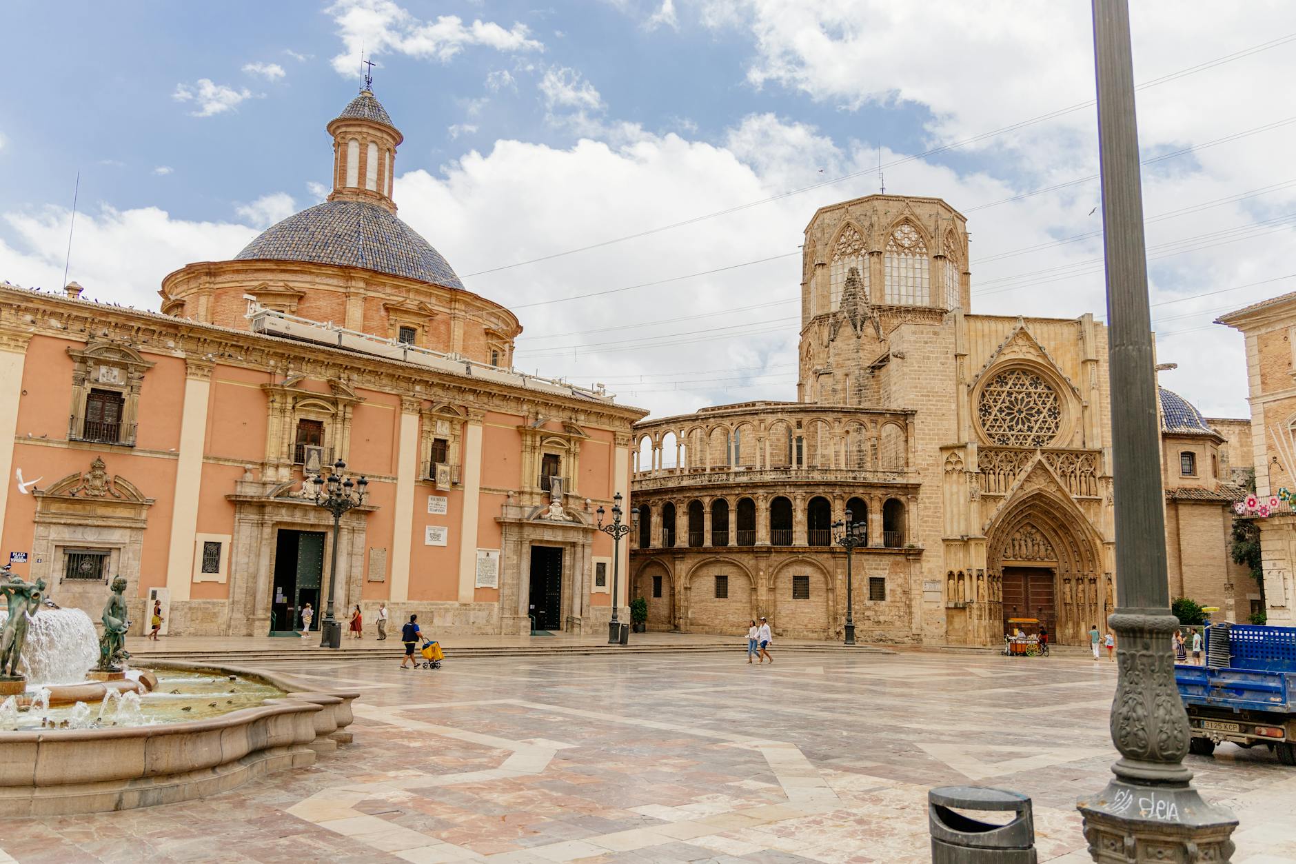 Valencia Cathedral and the fountain at Plaza de la Virgen under blue skies