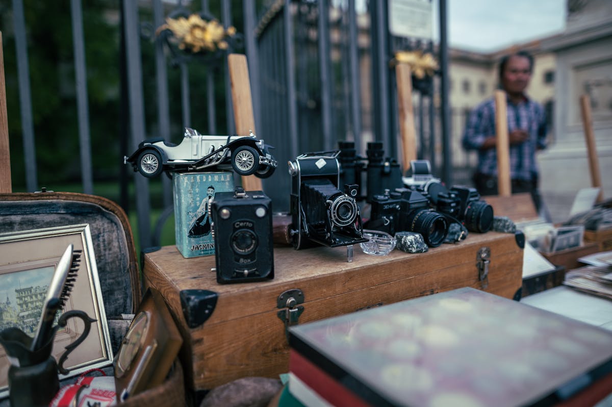Vintage cameras and collectibles displayed at an outdoor flea market