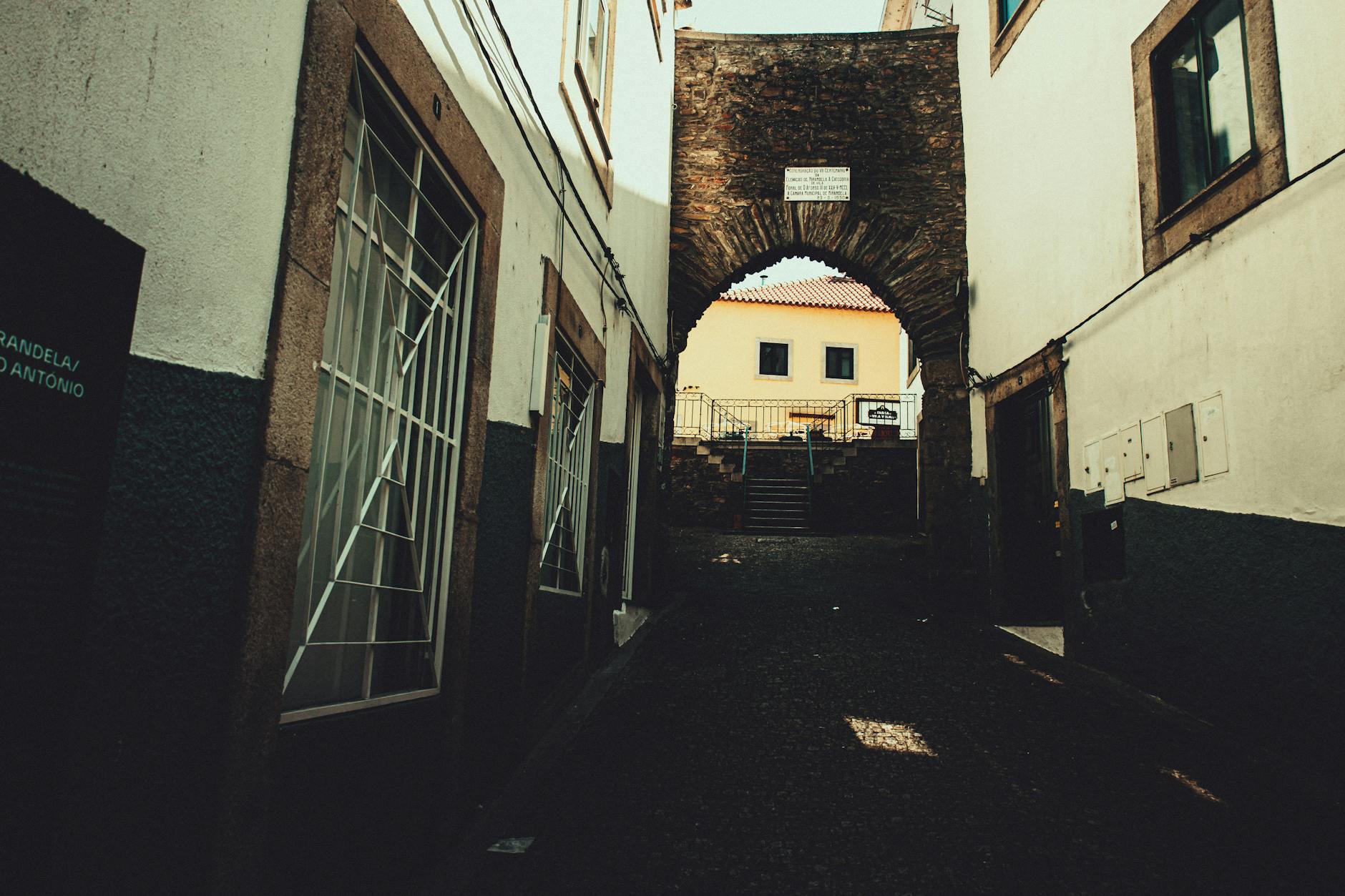 Historic stone archway in a narrow cobblestone alley in Valencia old town