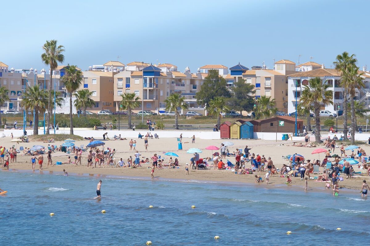 Busy summer day at Malvarrosa beach in Valencia with beachgoers along the Mediterranean coast