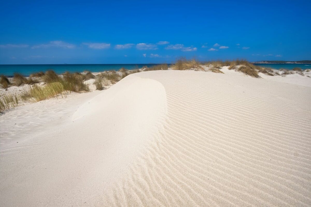 Pristine white sand dunes under clear blue sky at a quiet Mediterranean beach