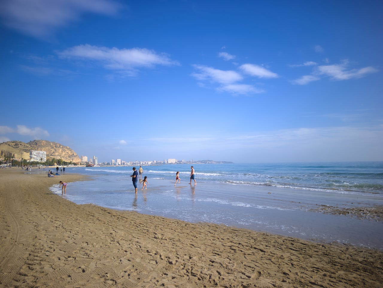 Family enjoying a sunny day at a sandy beach on the Spanish Mediterranean coast