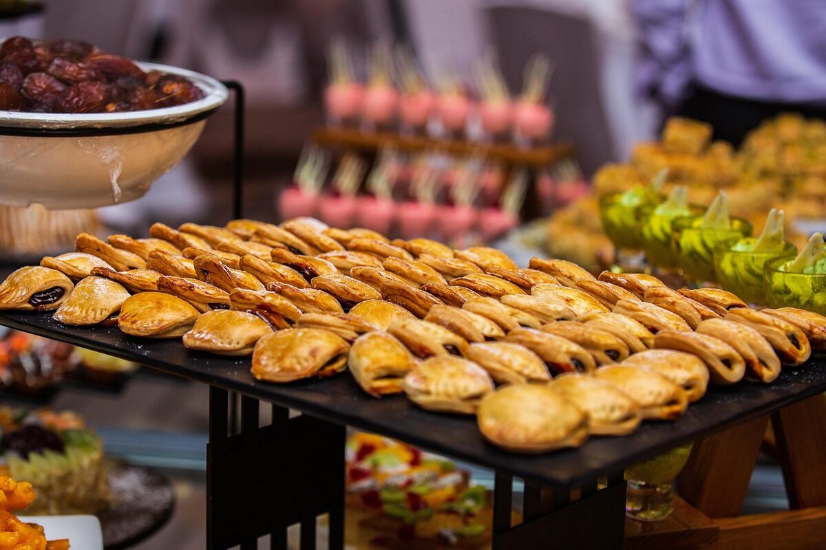 Golden empanadas lined up at a buffet display ready to be served