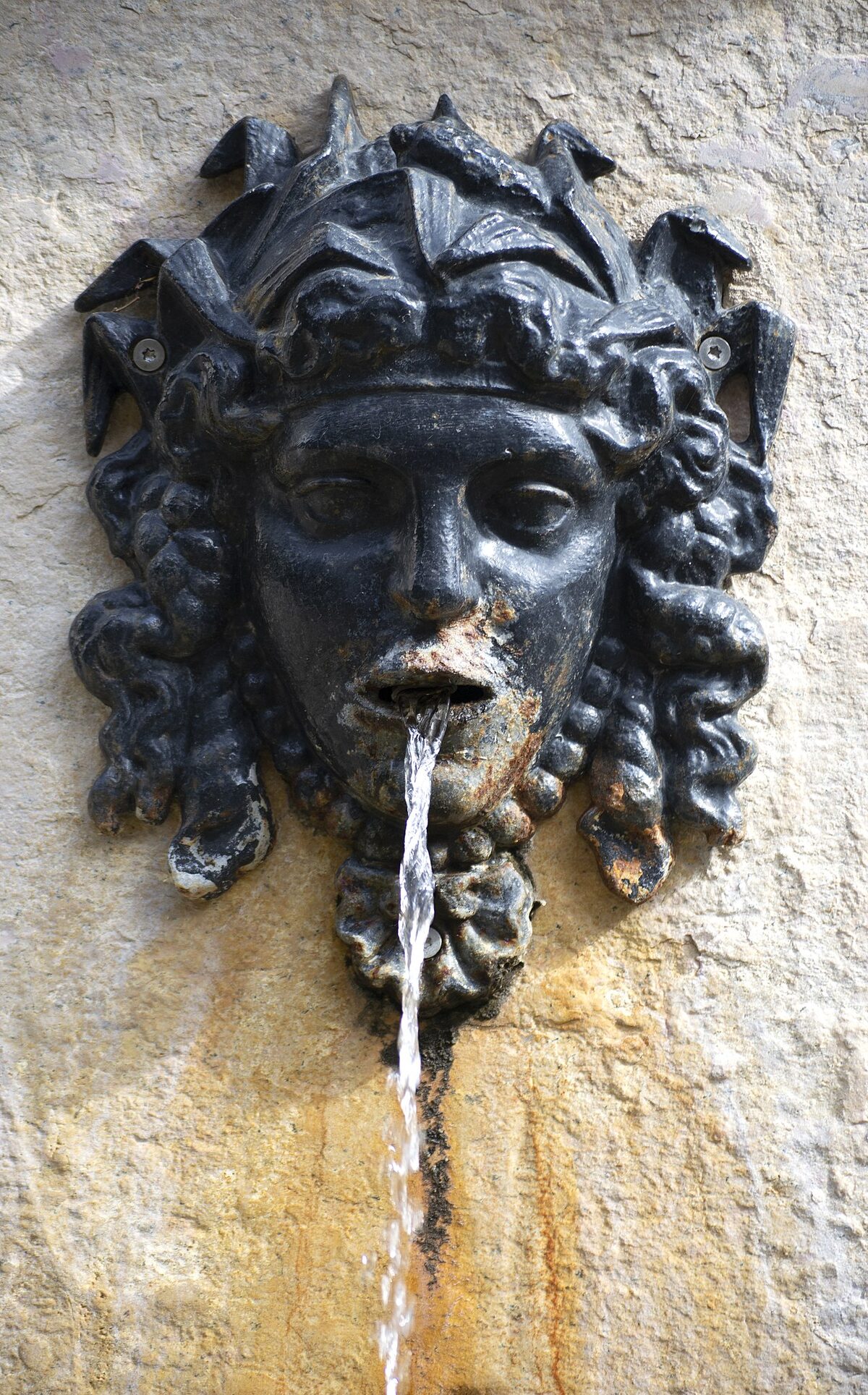 Stone fountain surrounded by sculpted hedges in Jardines de Monforte Valencia