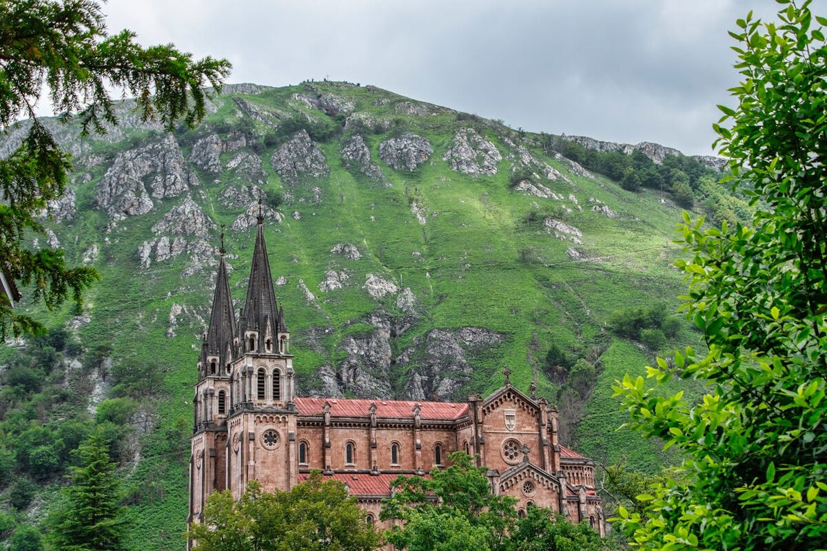 A basilica set against green mountains in the Spanish countryside