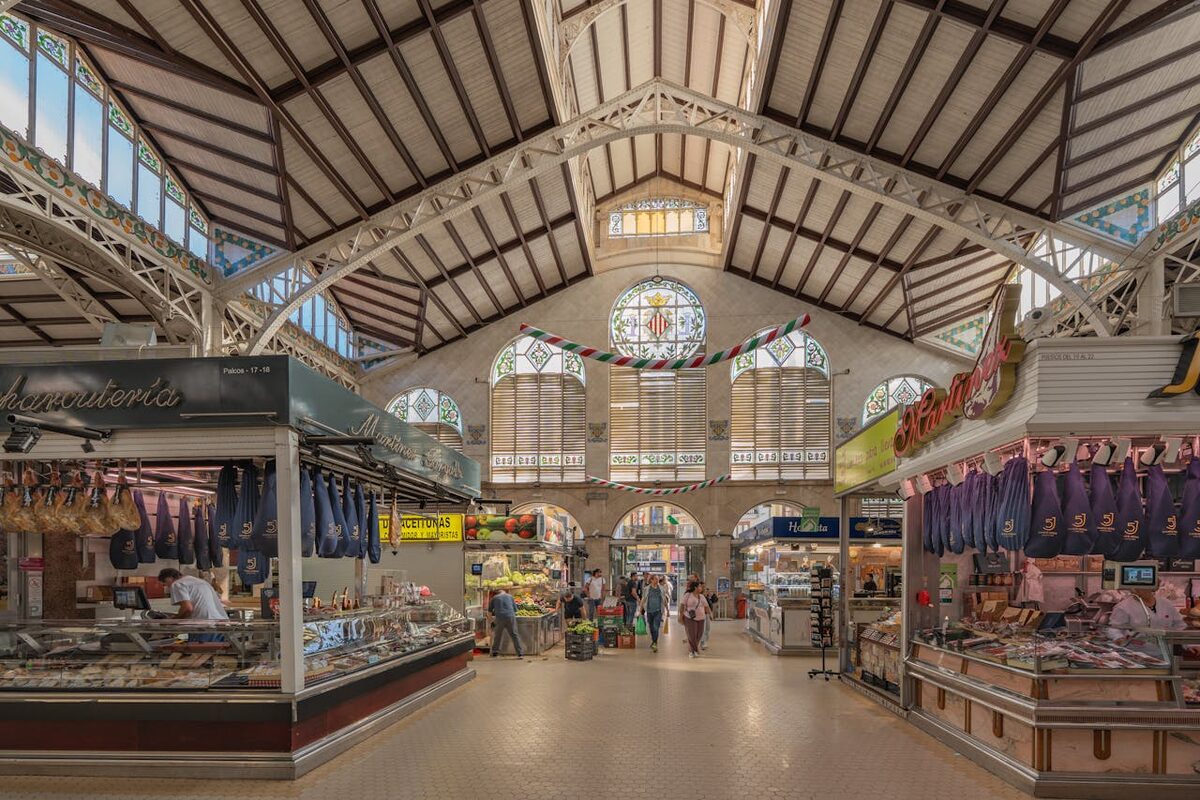 Colorful food stalls with fresh produce inside a Valencia market hall