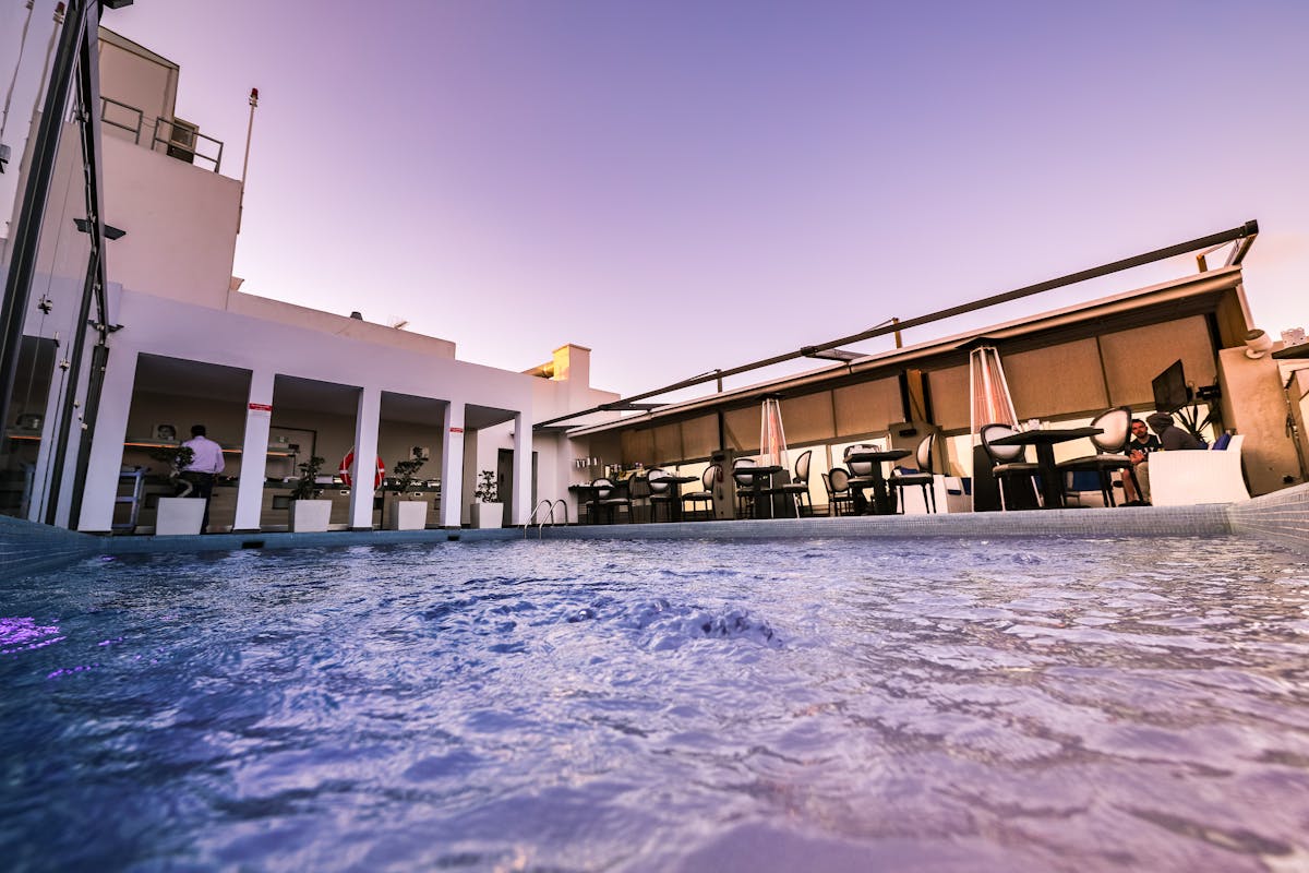 Luxurious rooftop terrace lounge area overlooking a city during a colorful sunset
