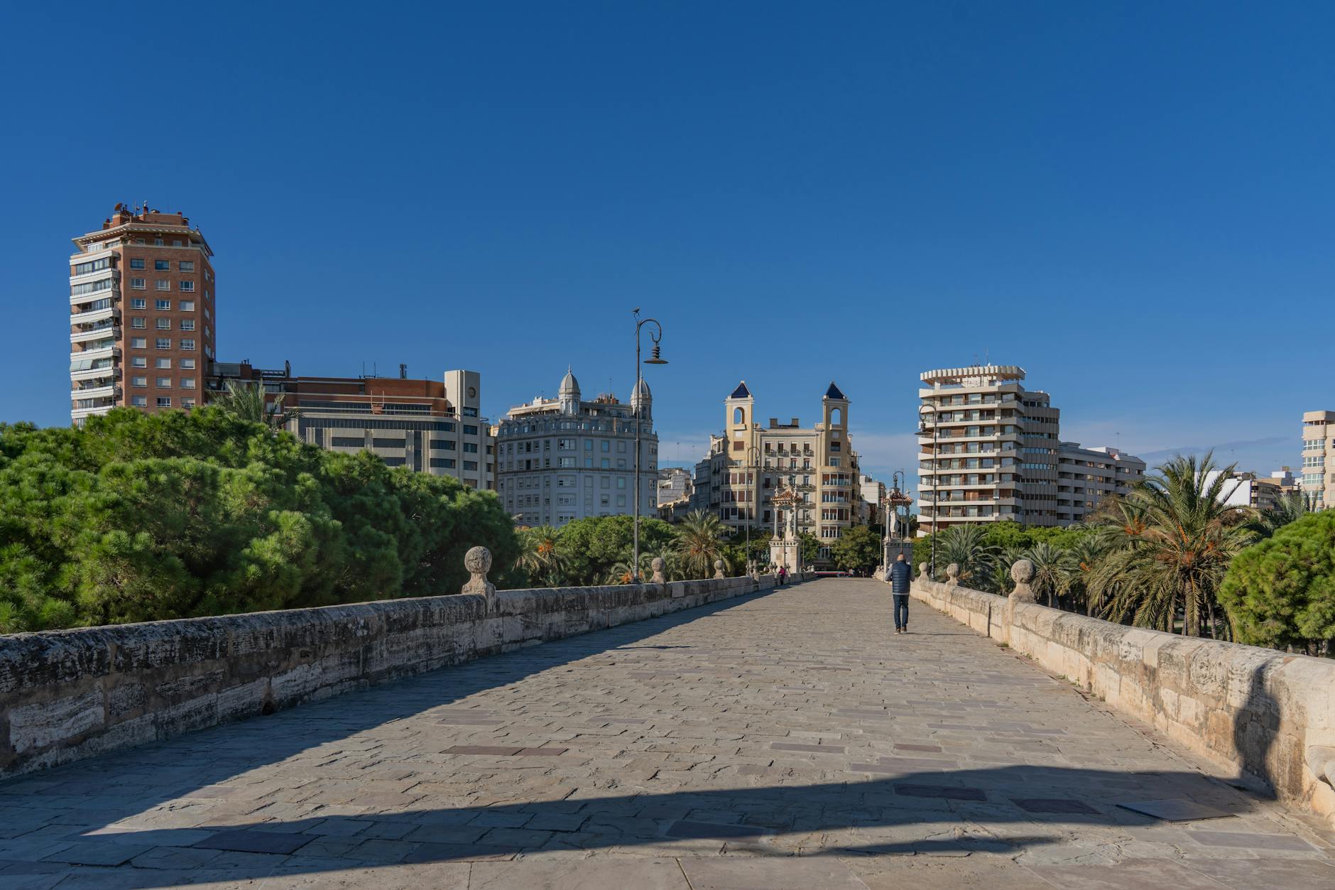 View of Valencia city skyline from a historic stone bridge on a clear day