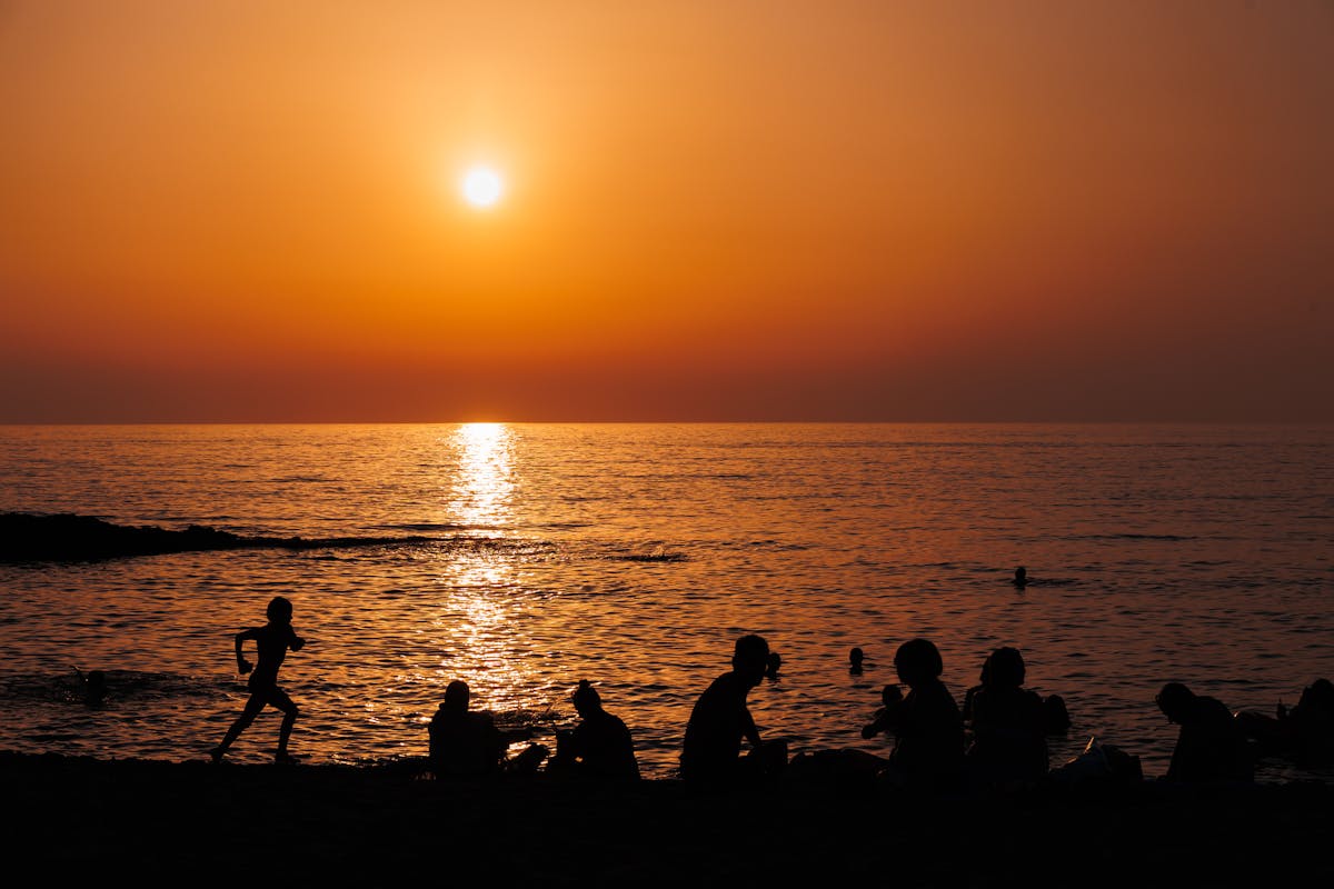 Silhouetted people enjoying a sunset at the beach