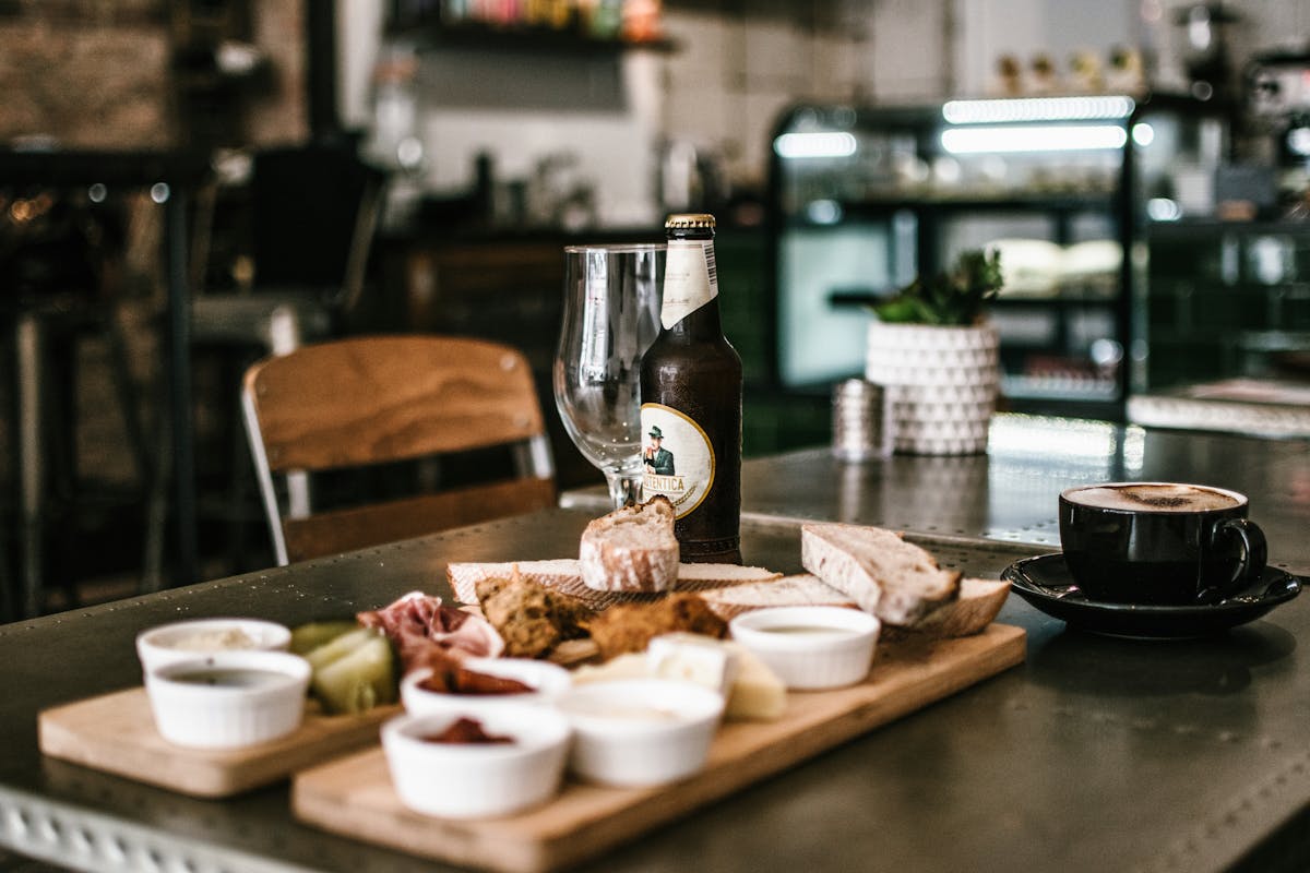 Craft beer and deli platter with snacks at a cozy bar table