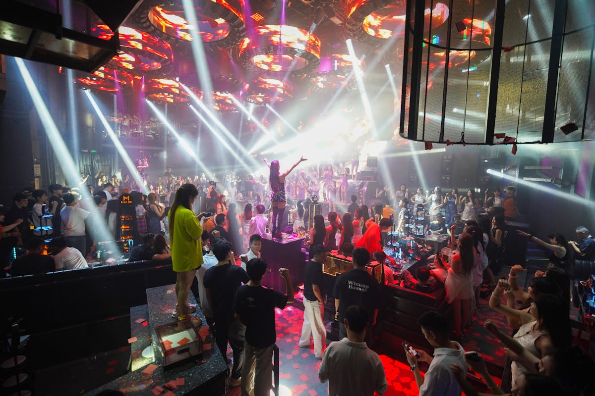 Crowded nightclub dance floor with colorful lighting and energetic crowd