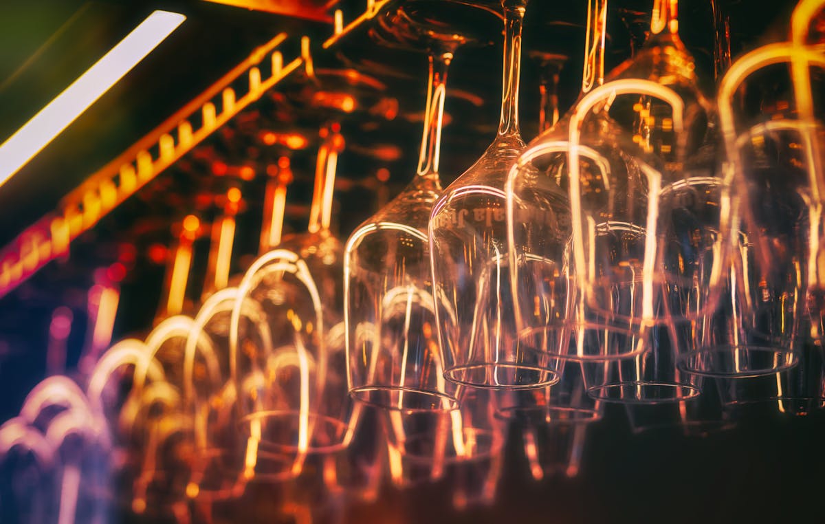 Close-up of hanging wine glasses in warm ambient lighting at a Spanish bar