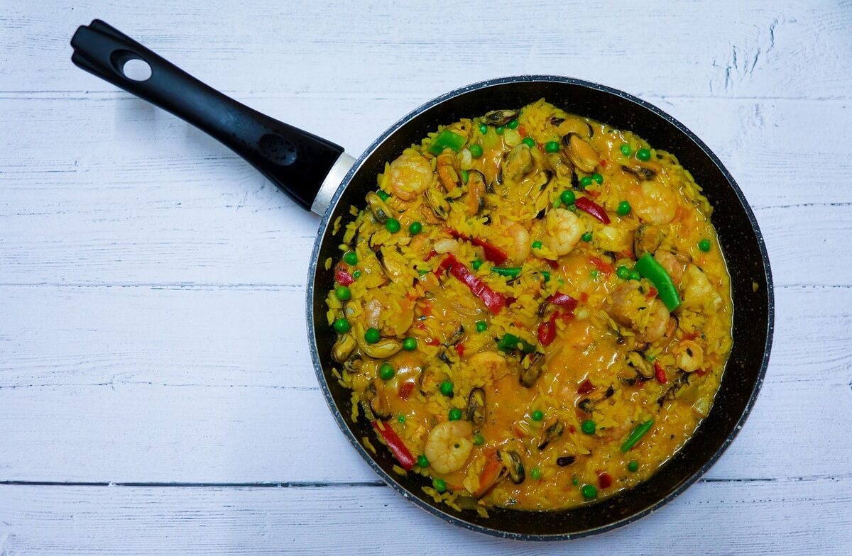 Seafood paella in a traditional pan with shrimp and mussels