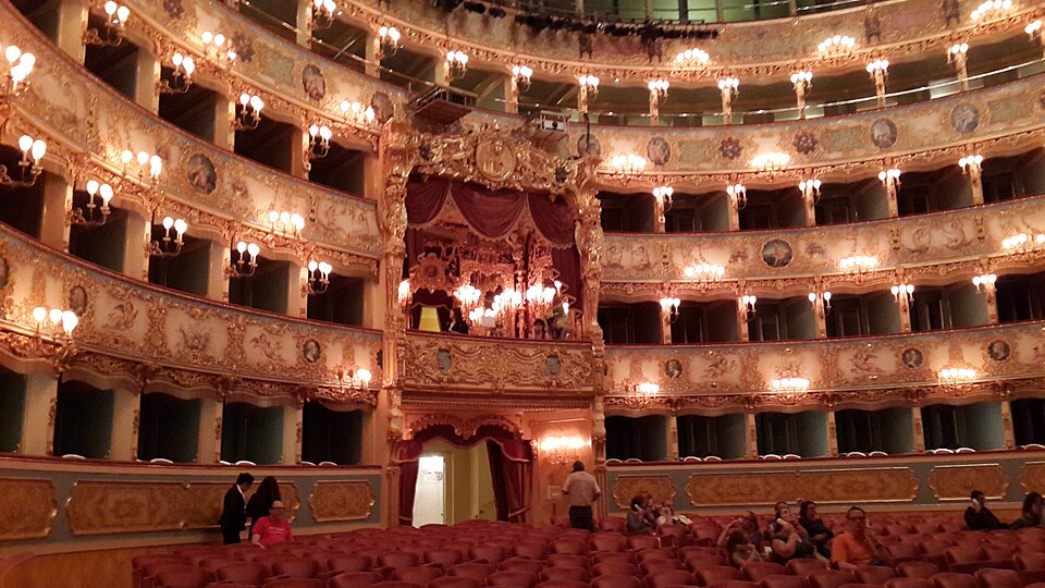 The ornate interior of Teatro La Fenice opera house in Venice showing gilded box seats and the painted ceiling