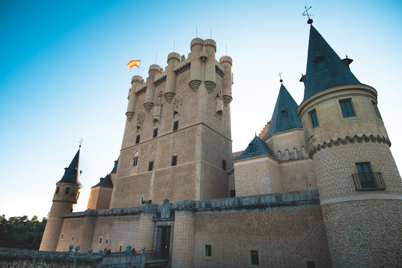 The Alcazar of Segovia with its pointed turrets and Gothic architecture, resembling a fairytale castle