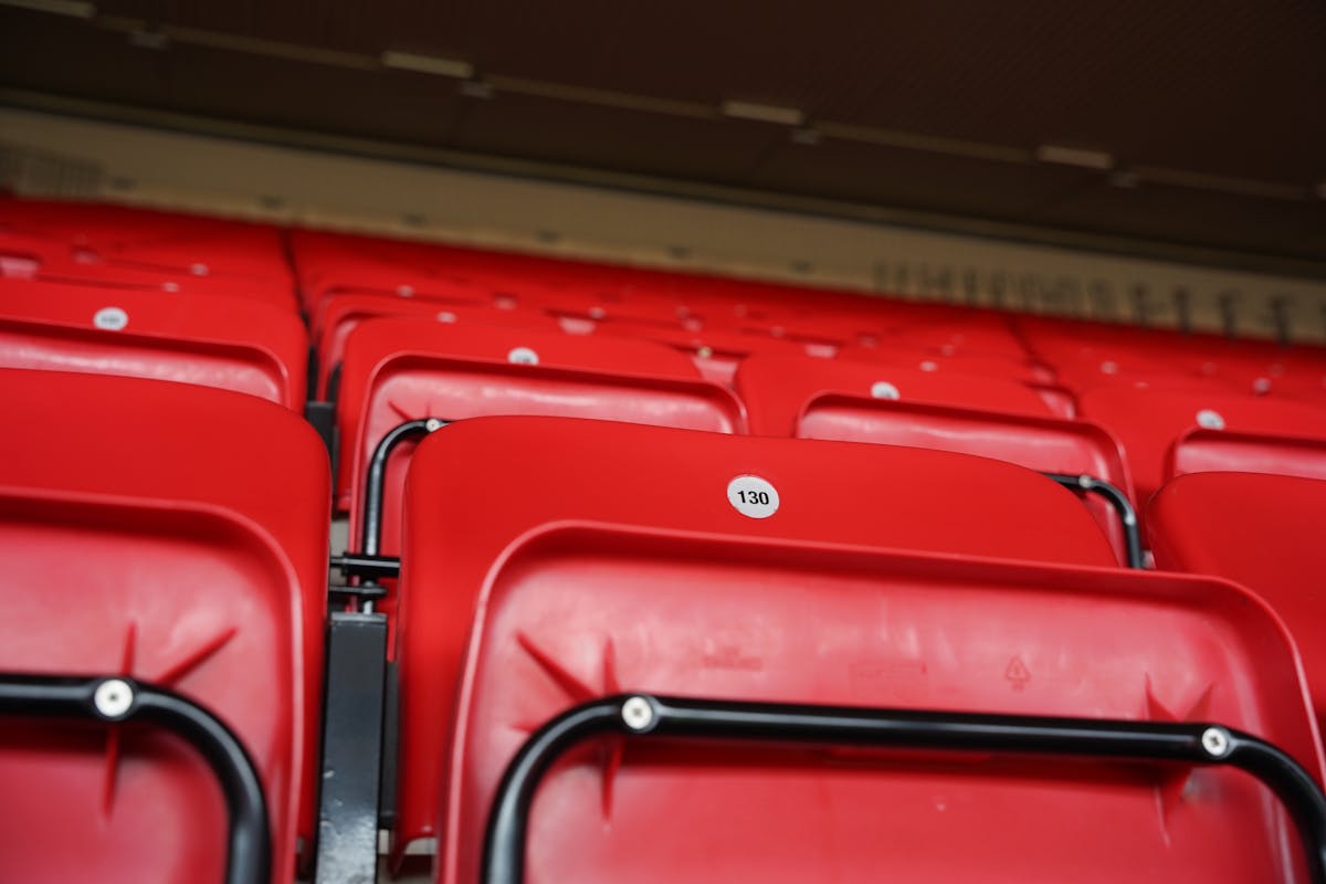 Close up of numbered red seats inside Anfield Stadium